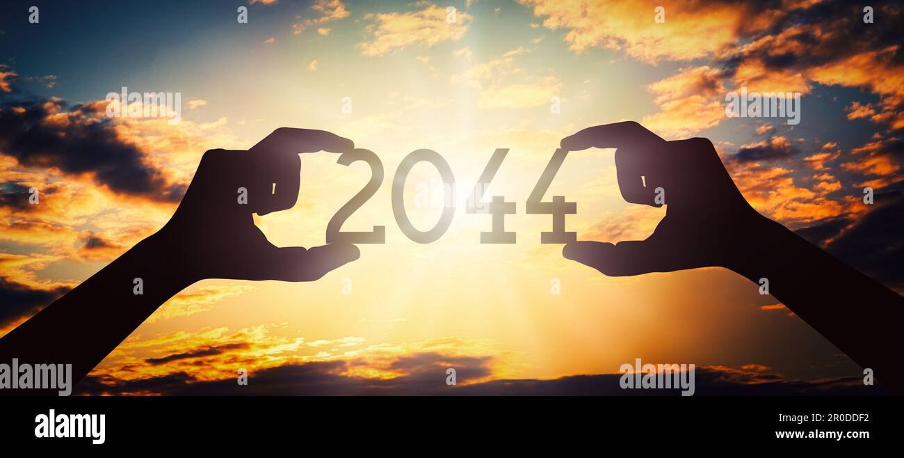 2044 - human hands holding black silhouette year number Stock Photo - Alamy
