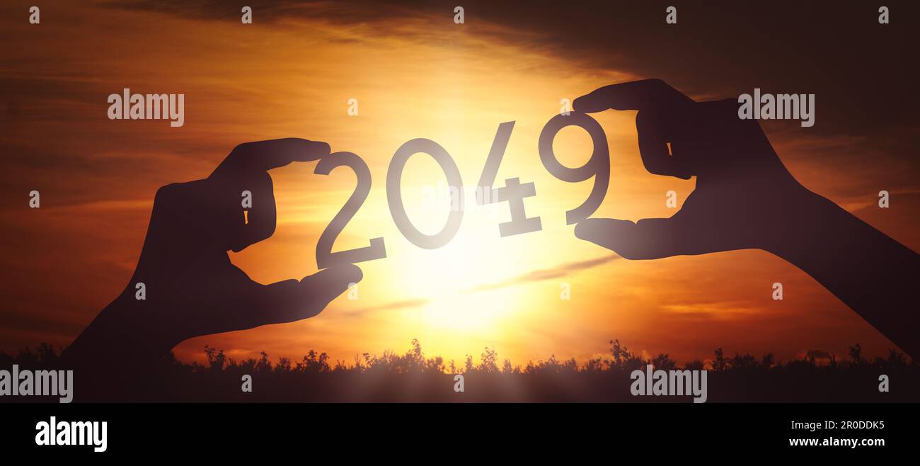 2049 - human hands holding black silhouette year number Stock Photo - Alamy