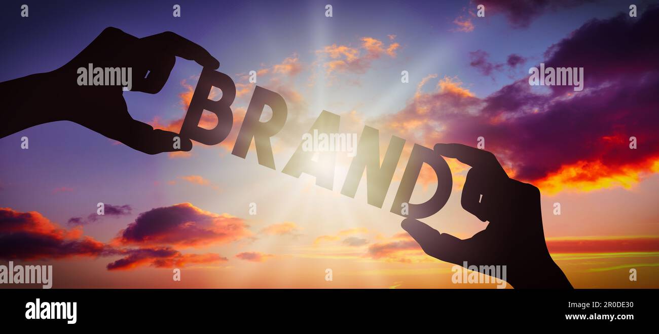 Brand - human hands holding black silhouette word Stock Photo - Alamy