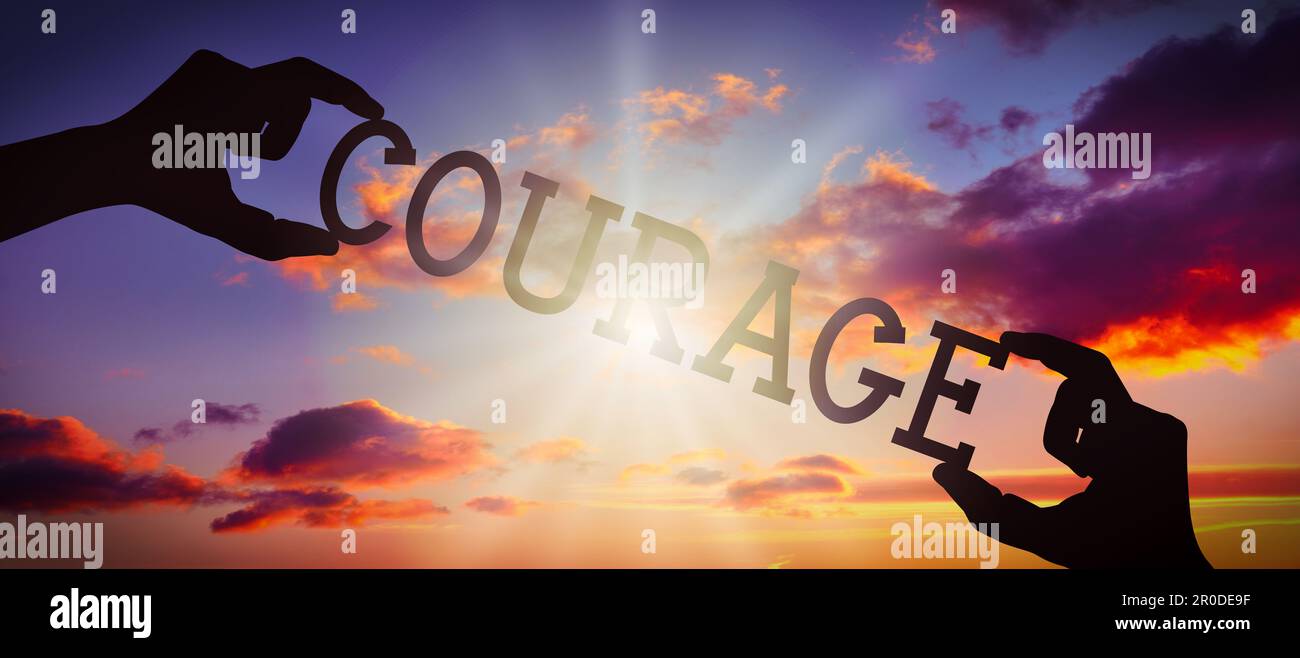 Courage - human hands holding black silhouette word Stock Photo - Alamy