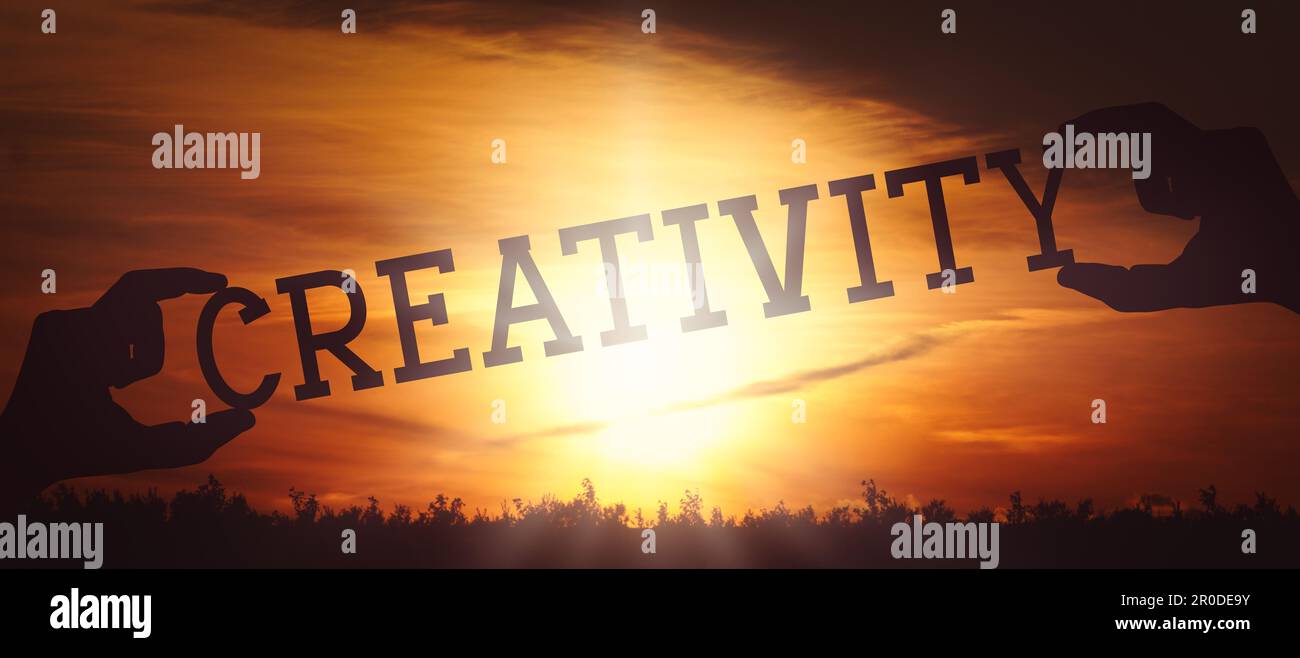 Creativity - human hands holding black silhouette word Stock Photo - Alamy