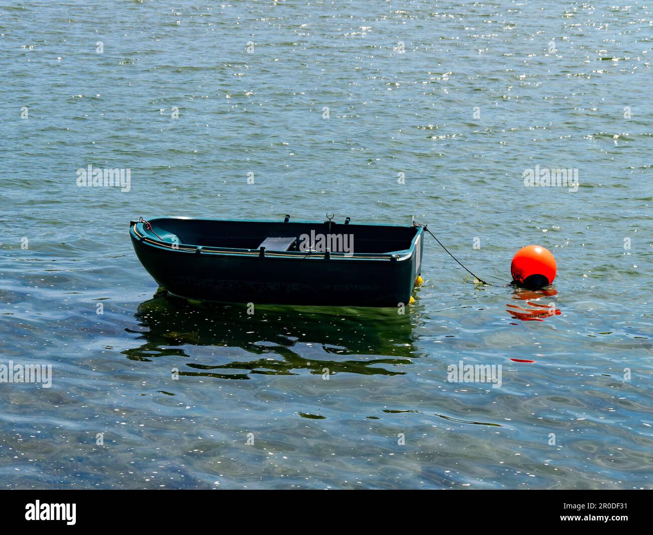 A small single-person plastic boat on the surface of the water. Orange ...