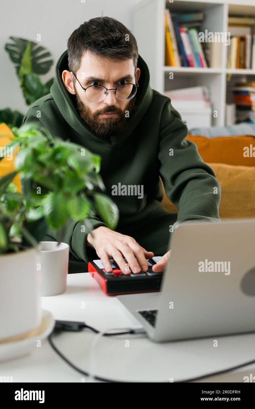Man recording electronic music track with portable midi keyboard on ...
