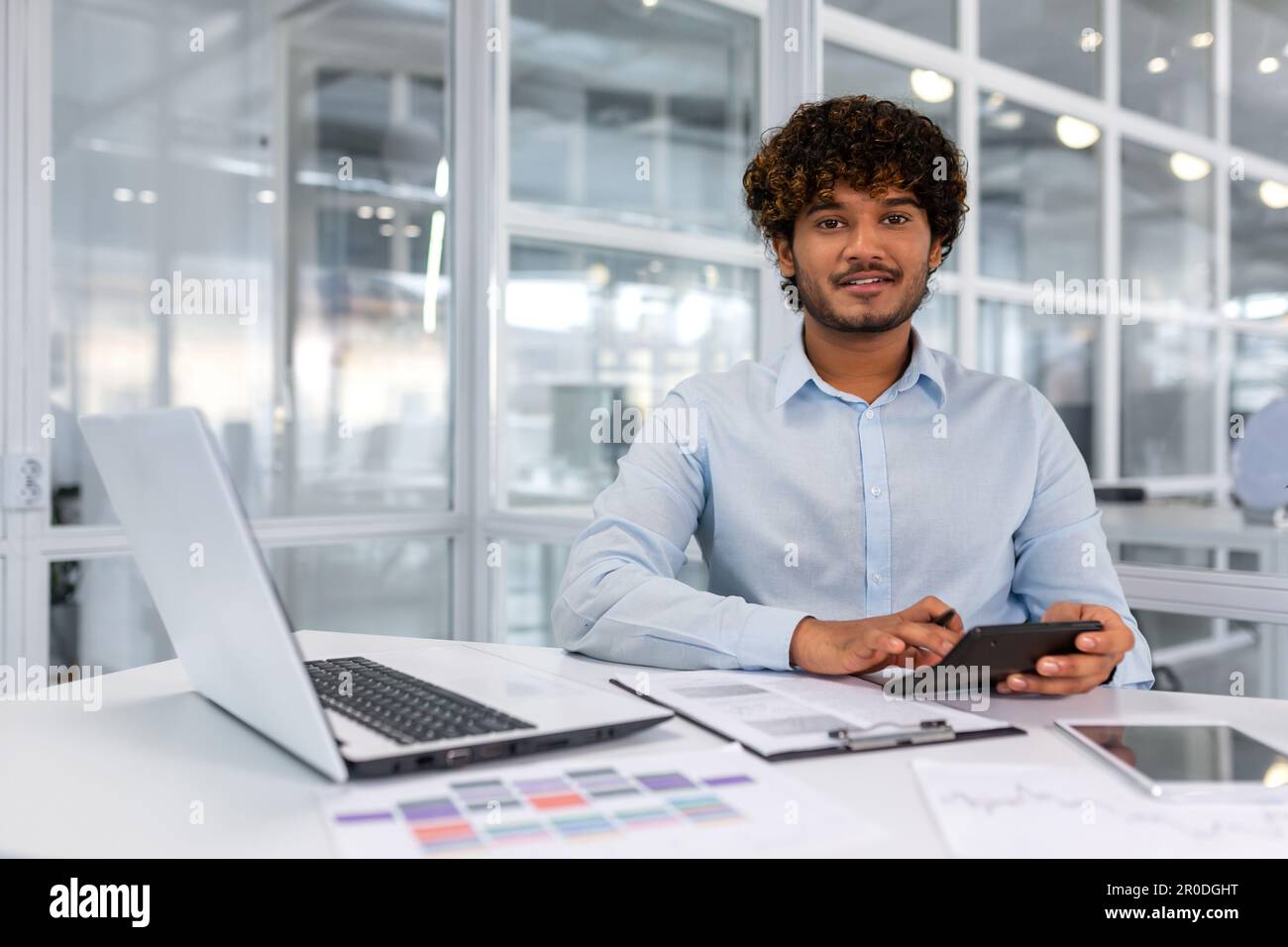 Portrait of young successful financier accountant at work inside office ...