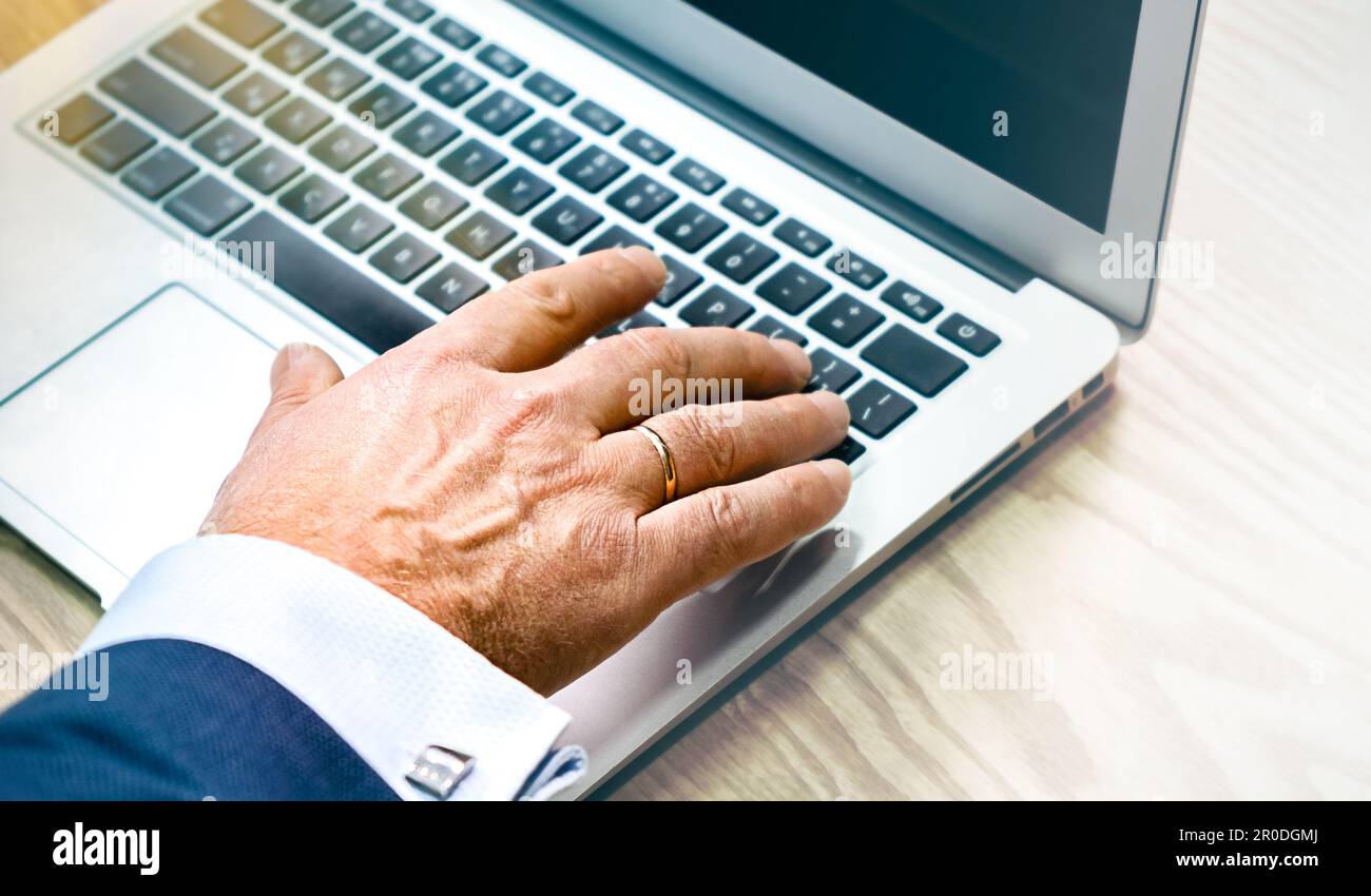 Banner with mature man working on laptop. Forefinger at keyboard ...