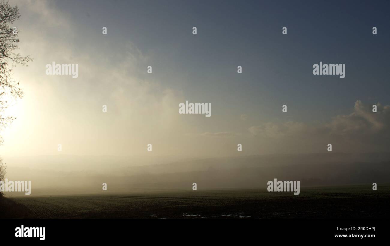 Fog rolling in over fields under sunshine Stock Photo - Alamy