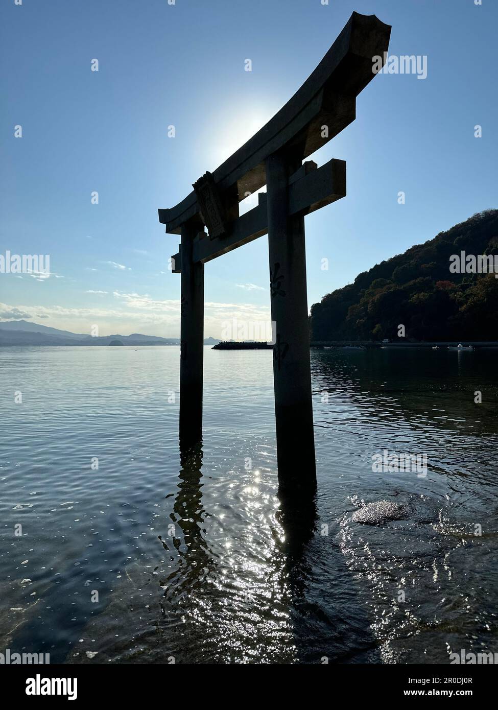 A traditional Japanese red torii gate standing in the sea in Seto Nakia ...