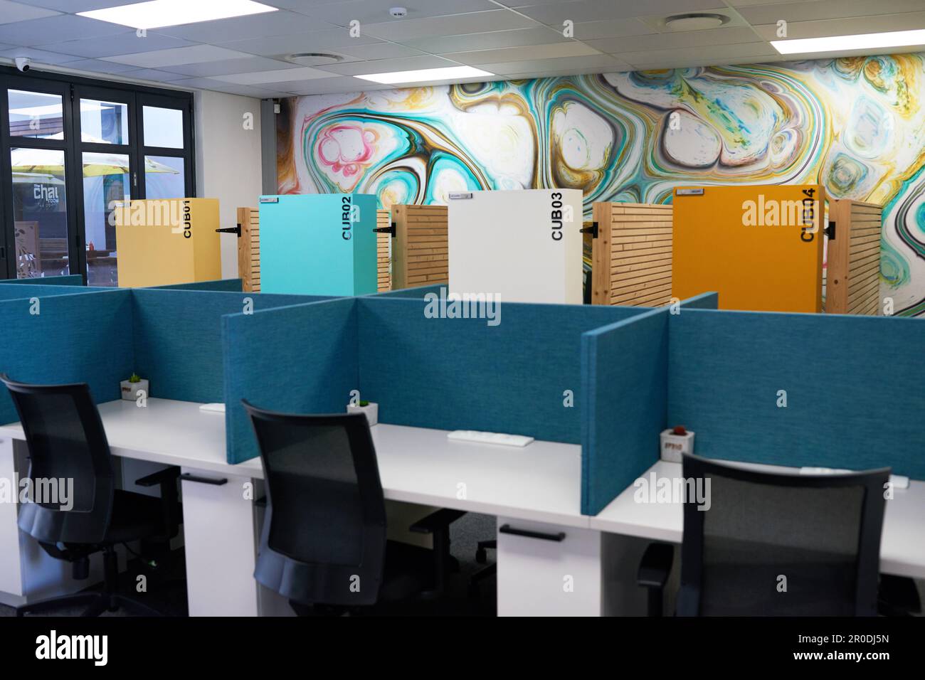 Empty modern office space with row of desks separated by desk dividers ...