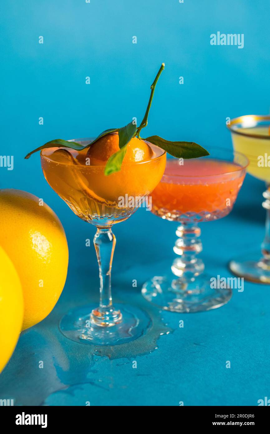 A still life of messy citrus cocktails on teal blue background Stock ...