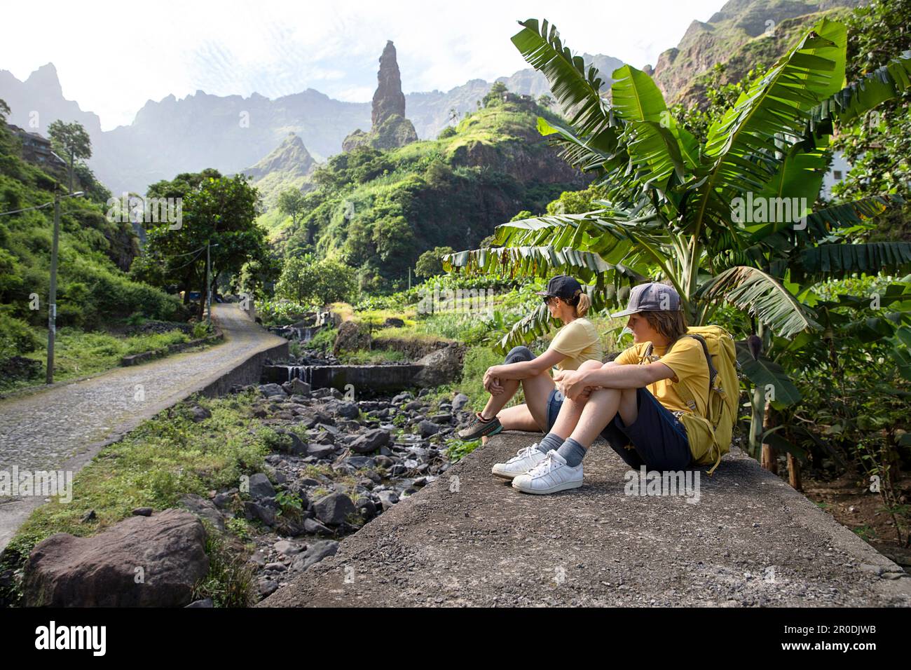 Tourists mother son looking towards Xoxo village and rock monolith in a spectacular lush valley ...