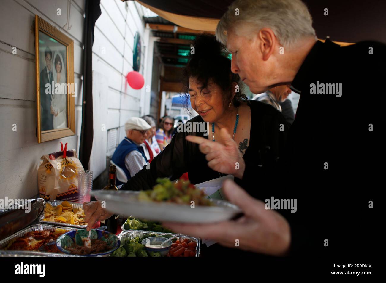 Maria Mosqueda (l to r) helps serve Father Tom Seagrave after he ...