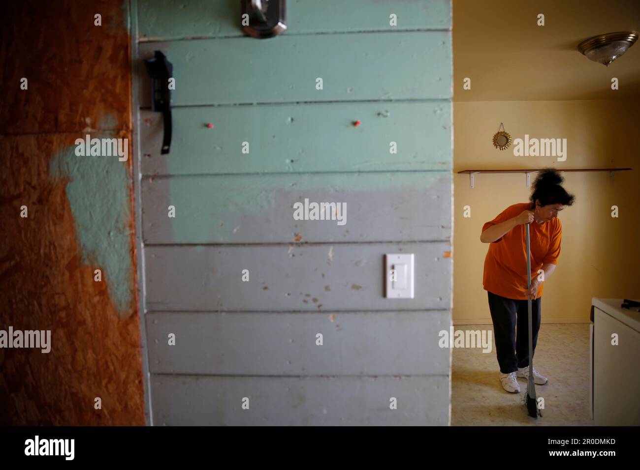 Maria Mosqueda sweeps the kitchen in a unit at the Mosqueda family home ...