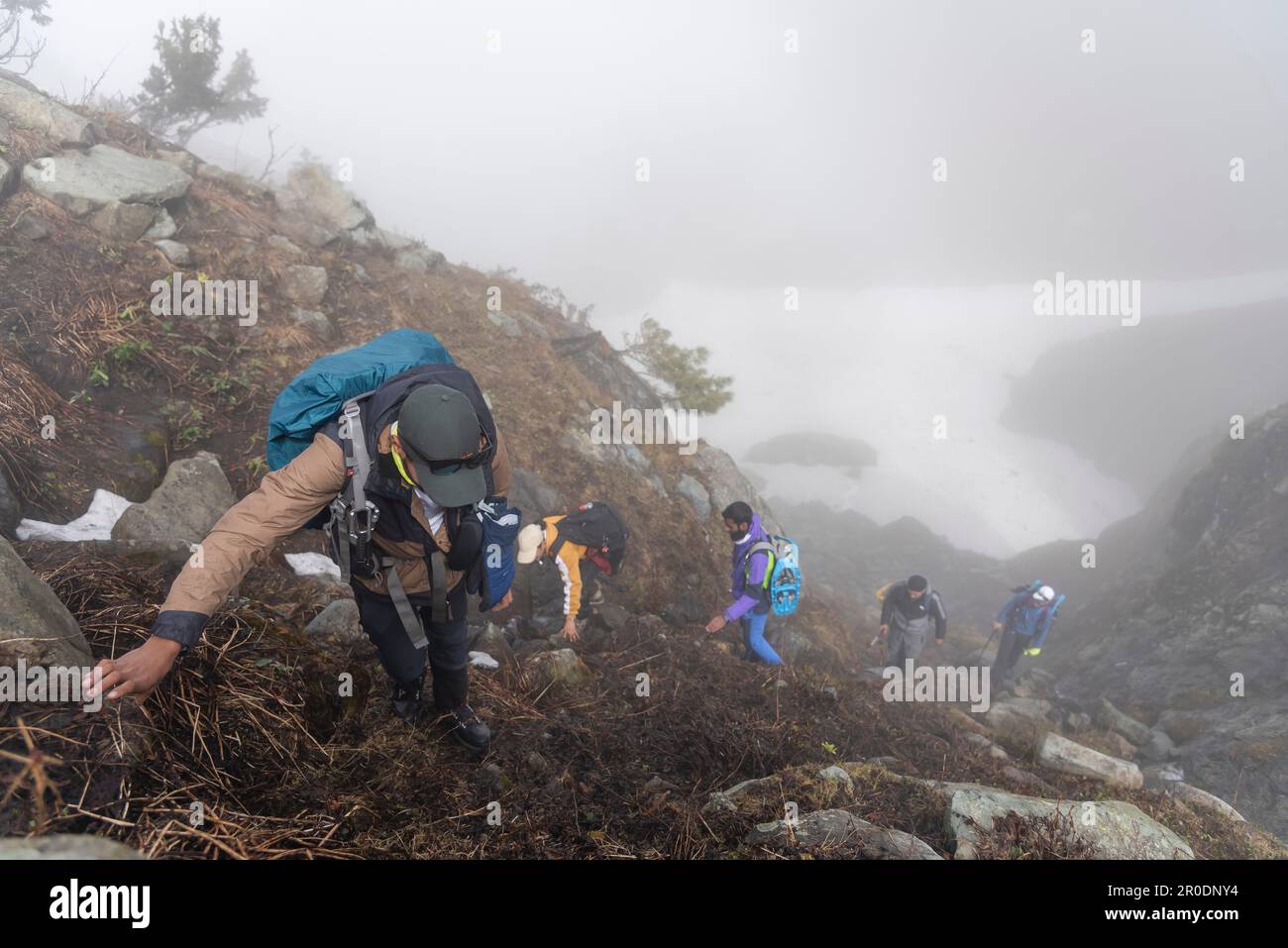 Trekkers hike through a cloud covered mountain enroute Soras Lake in ...