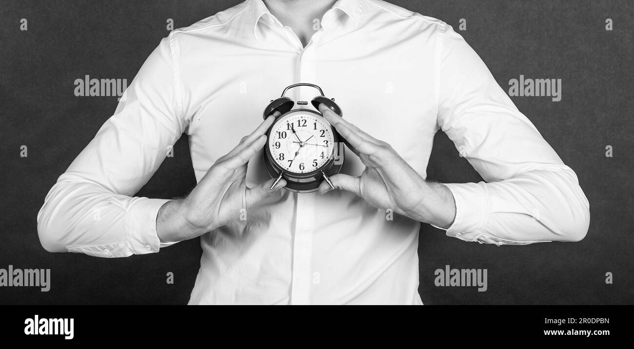 Man crop view hold alarm clock. Time management. Timing Stock Photo - Alamy