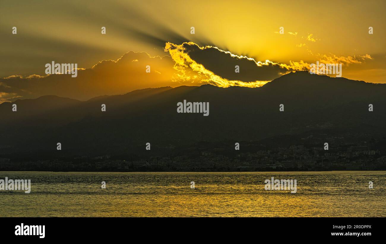 Warm sunset over the mountains of Sicily seen from the Strait of ...