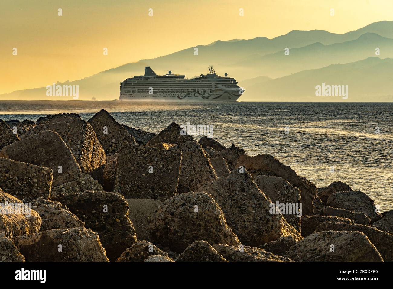 The cruise ship crosses the Strait of Messina illuminated by the warm ...