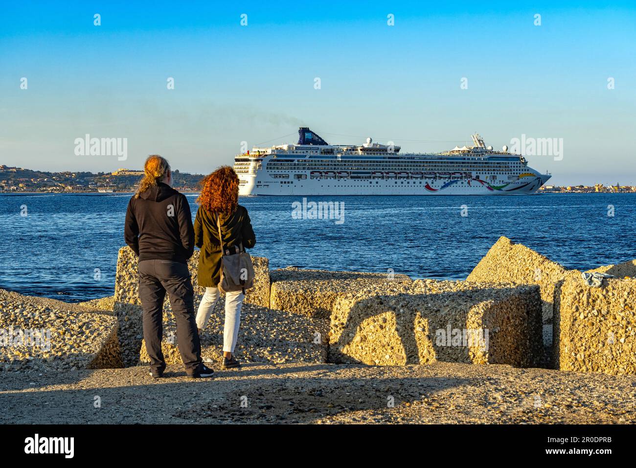 From the pier of the port of Villa San Giovanni, a couple of tourists ...