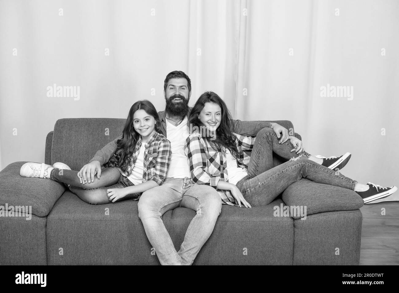 father mother and child on sofa. friendly family embrace. happy parents ...