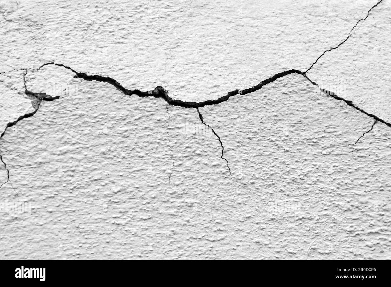 Big winding horizontal crack on old white plastering wall. Copy space ...