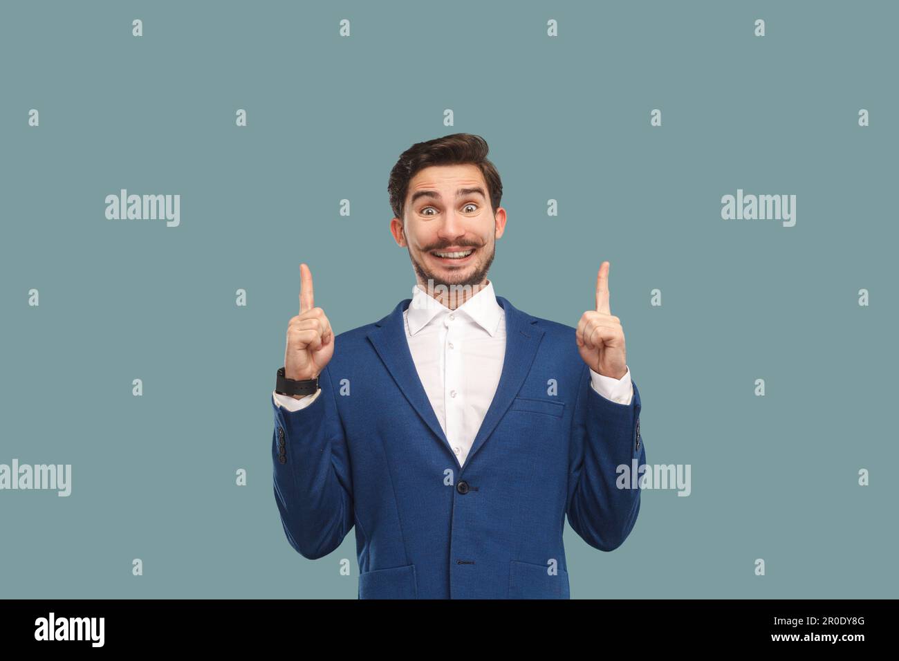 Portrait of smiling delighted man with mustache standing pointing ...
