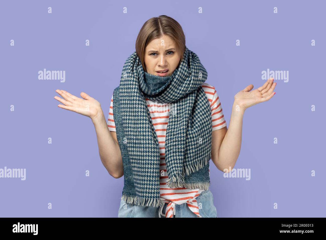 Portrait of confused helpless sick woman wearing striped T-shirt and ...