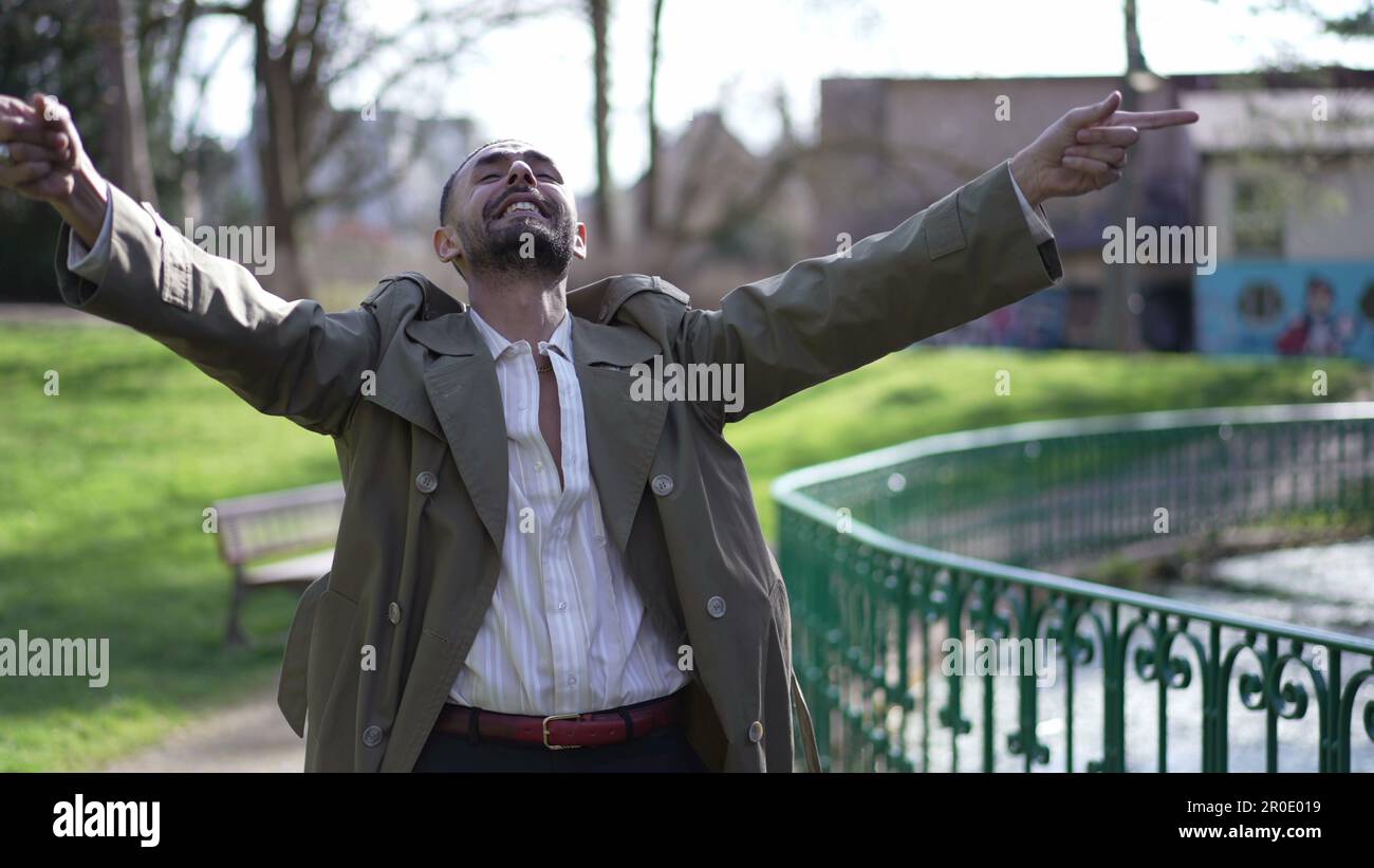 A Middle Eastern Man Exults in Triumph at a Sunny Park, Overflowing ...