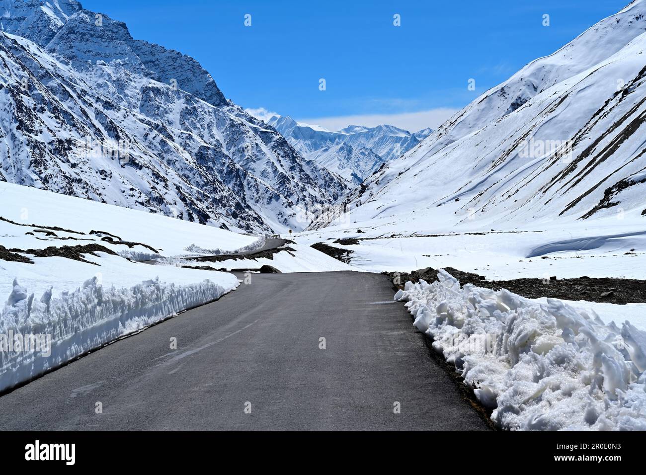 Road near the arrow sign vanishing in snow laden landscape Stock Photo ...