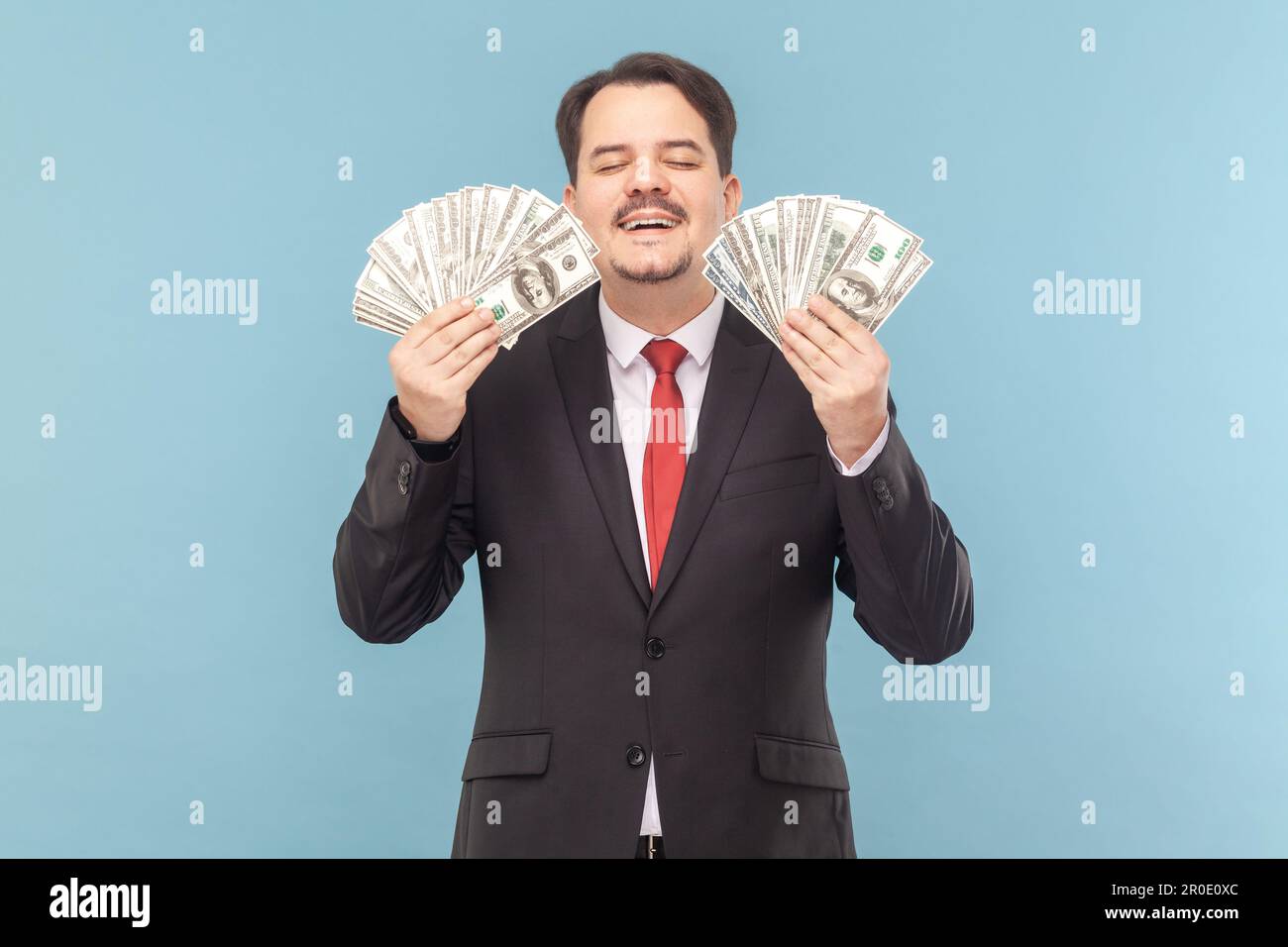Portrait of greedy smiling man with mustache standing with closed eyes ...