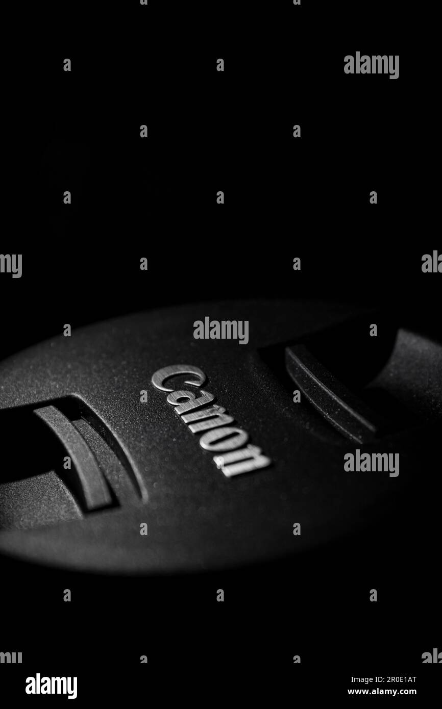 A close-up shot of a Canon camera lens cap in a monochromatic color scheme, highlighting the ...