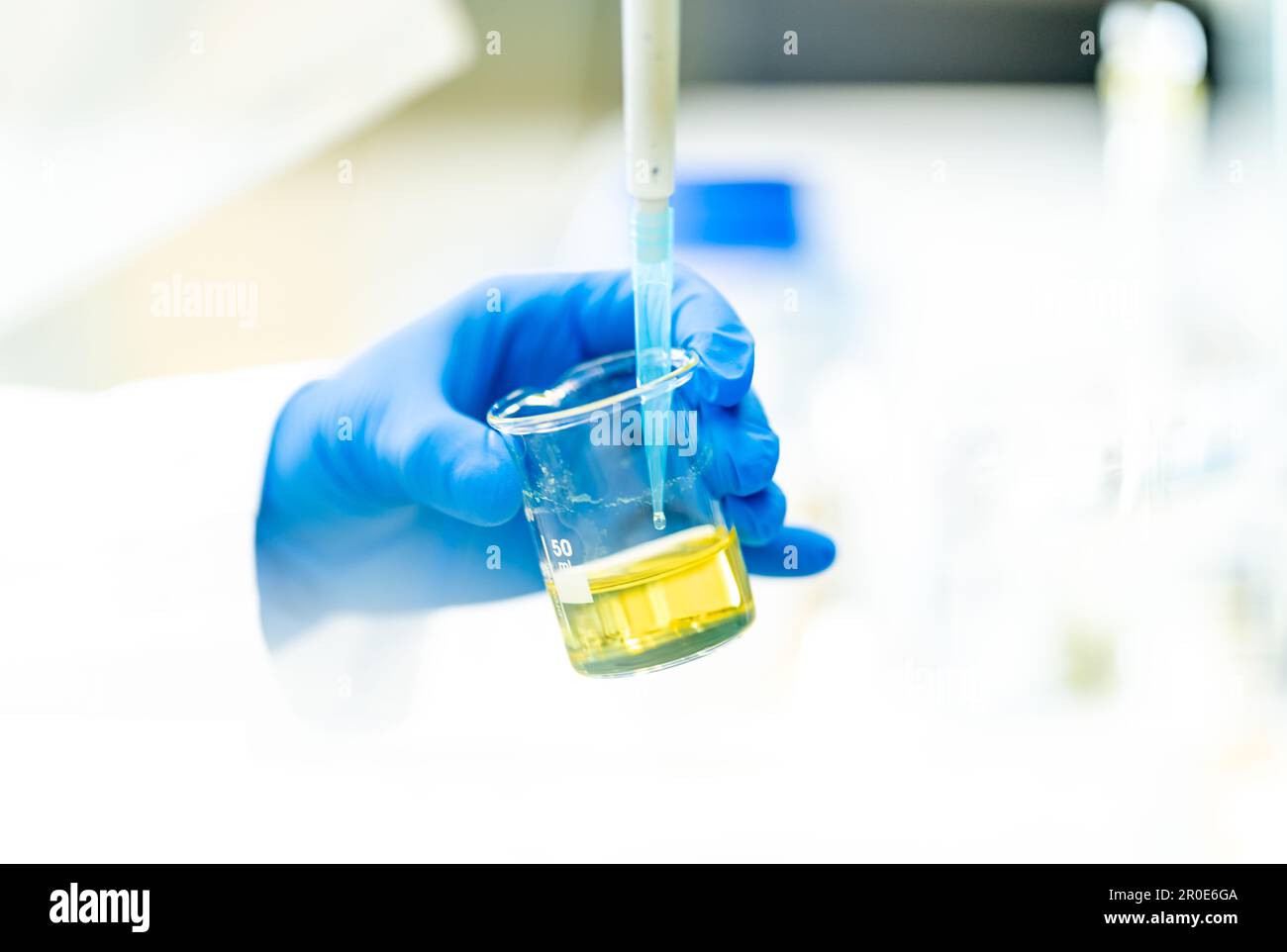 pipetting a chemical sample into research glass flasks Stock Photo - Alamy