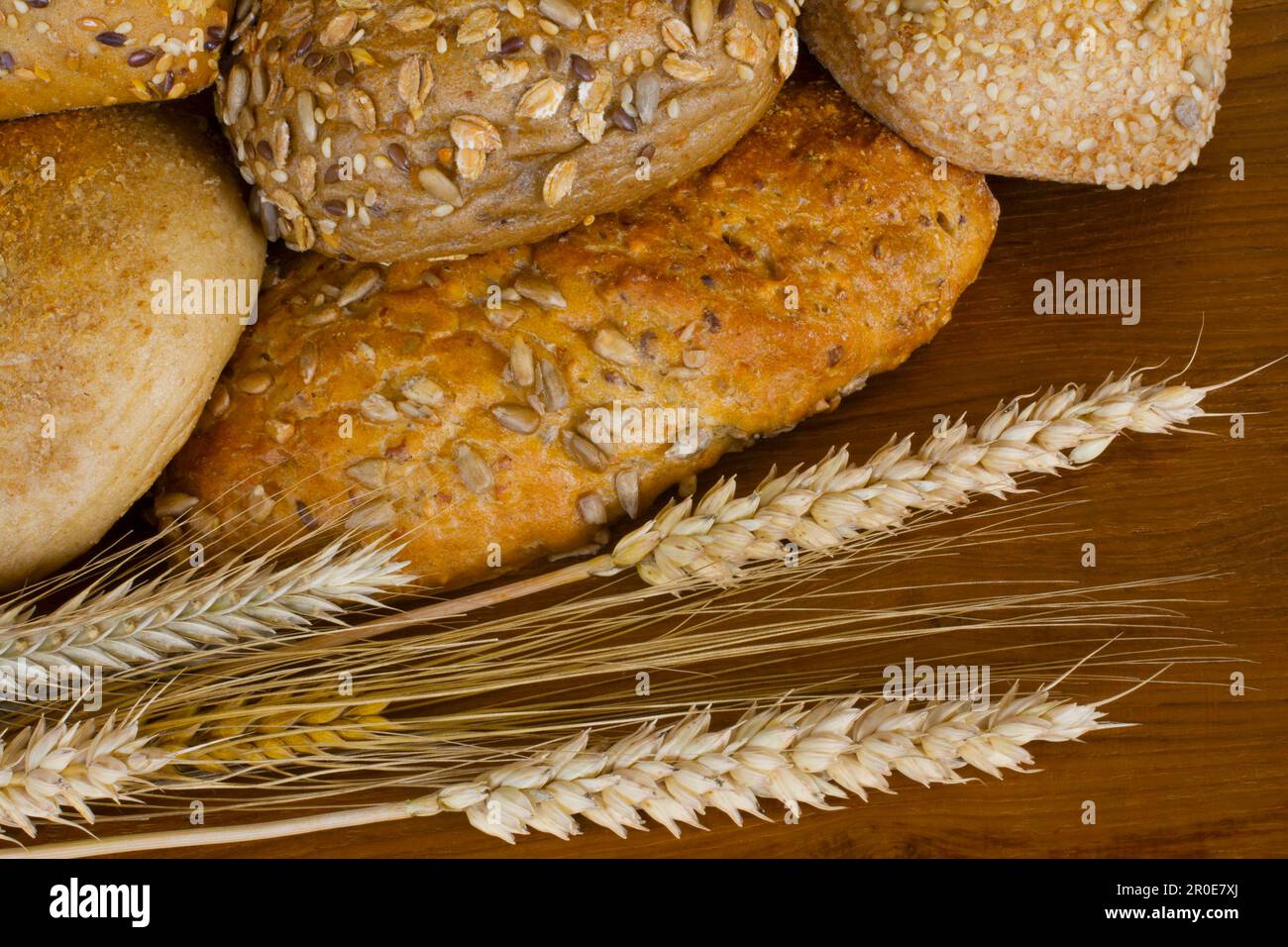 Whole grain rolls with ears of cereal in the foreground Stock Photo - Alamy
