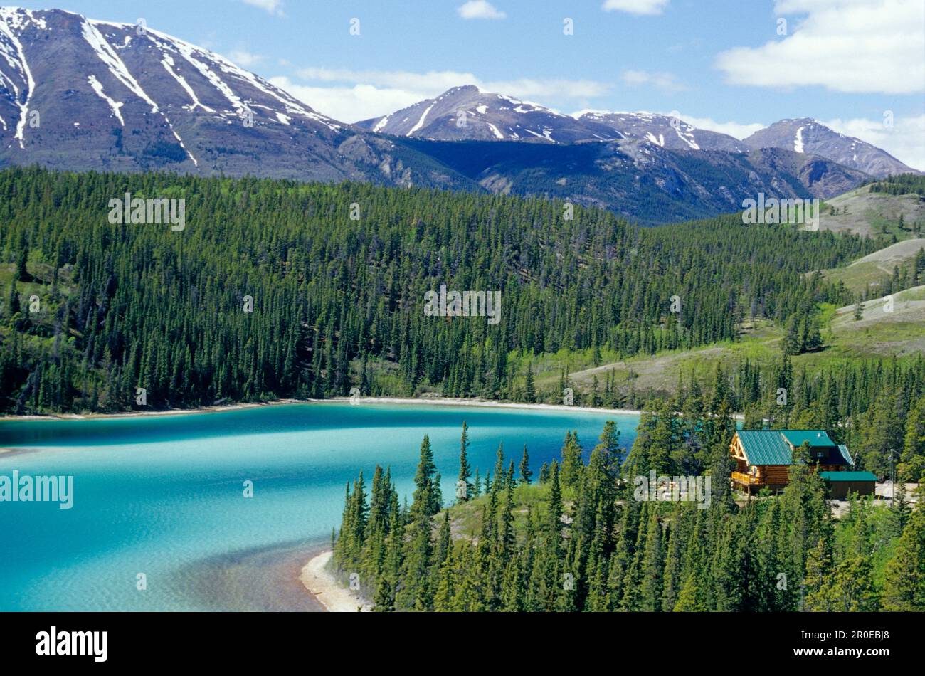 Cabin at Emerald Lake in front of snow covered mountains, Carcross ...