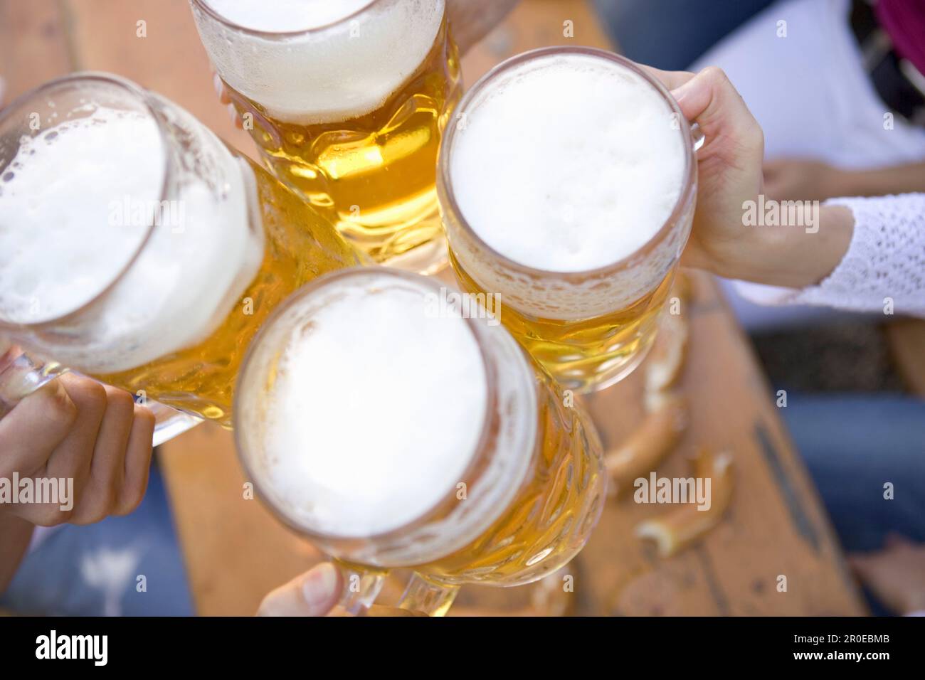 Four hands toasting with beer steins above table, Munich, Bavaria Stock ...