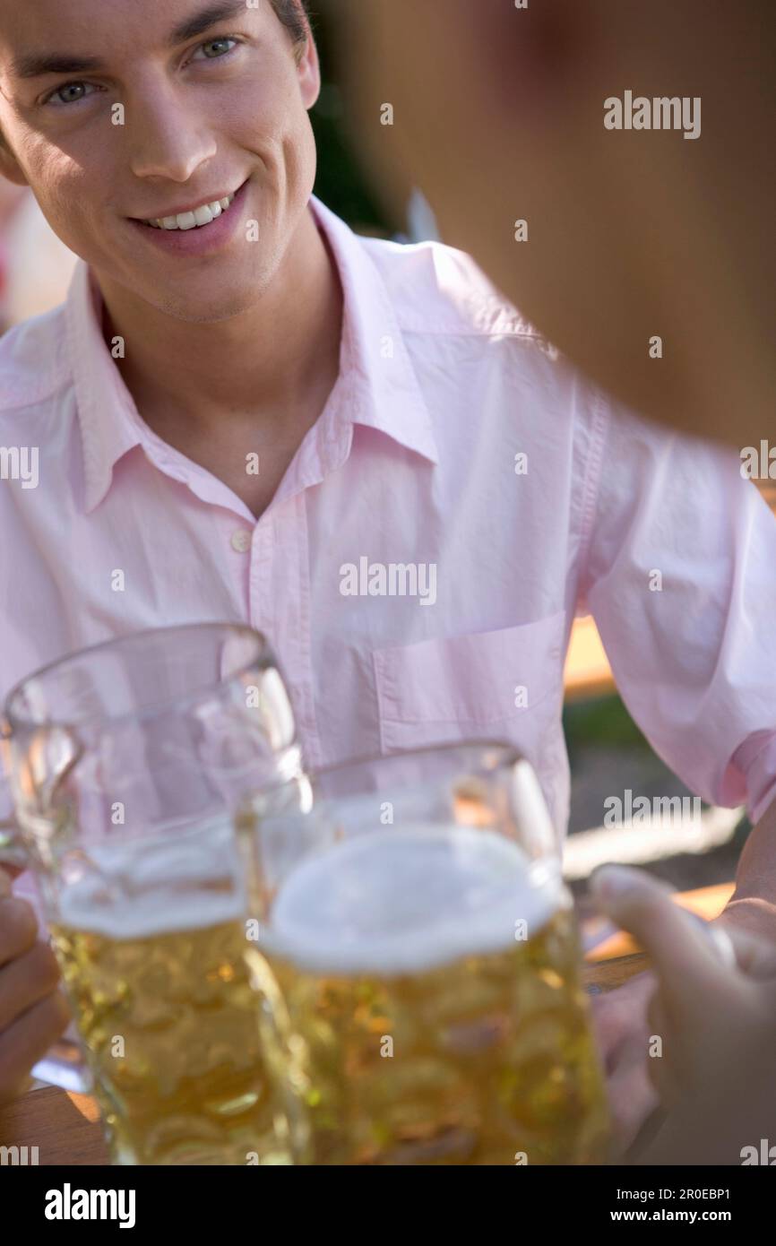 Smiling man toasting beer mug hi-res stock photography and images - Alamy