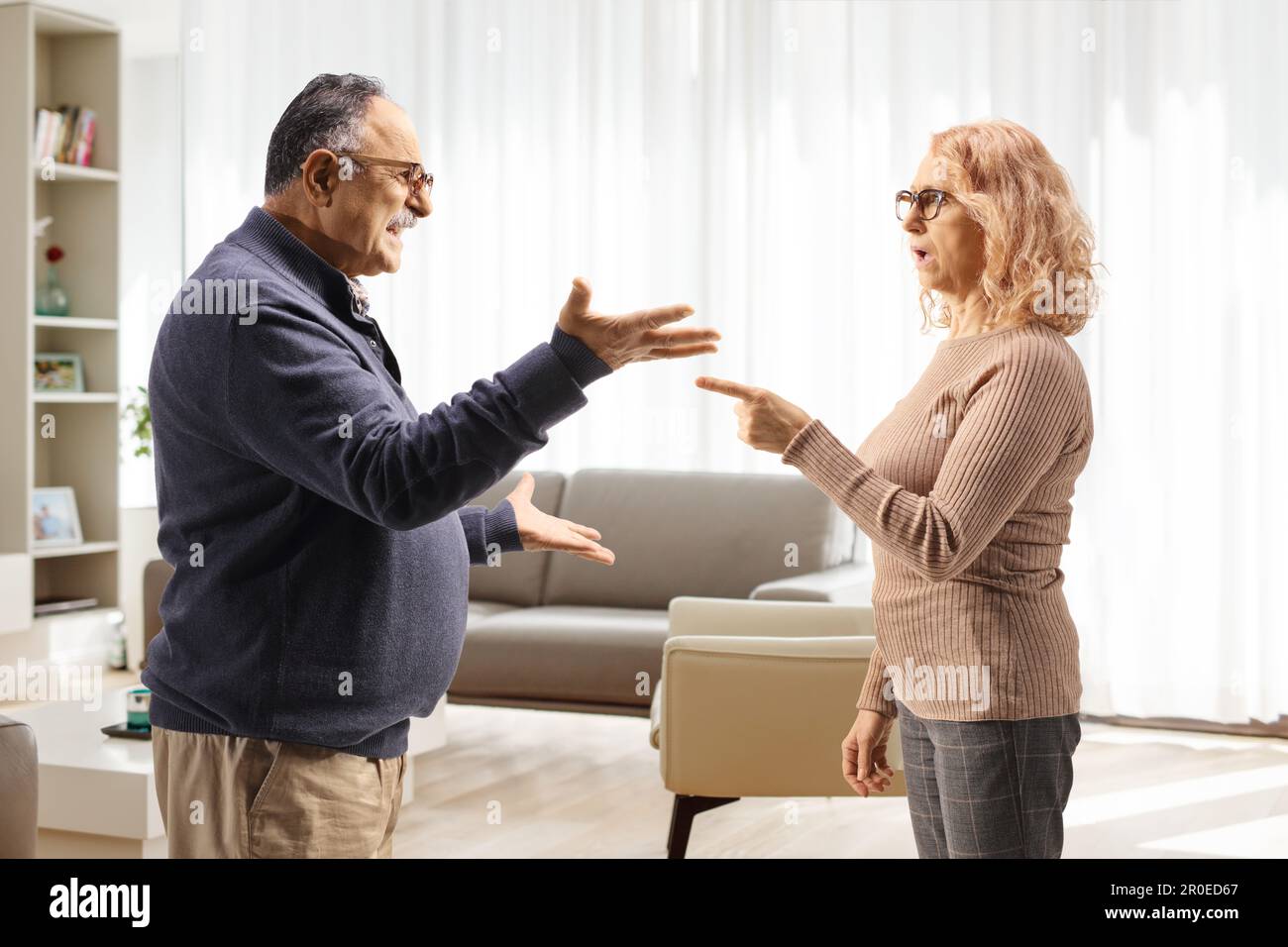 Husband and wife arguing at home in a living room Stock Photo - Alamy