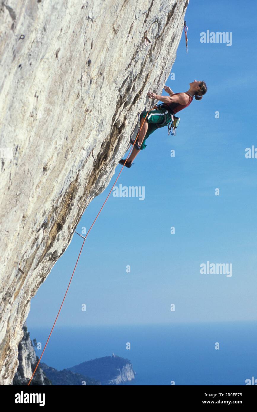 Female free climber scaling rock face, Muzzerone, Portovenere, Cinque ...