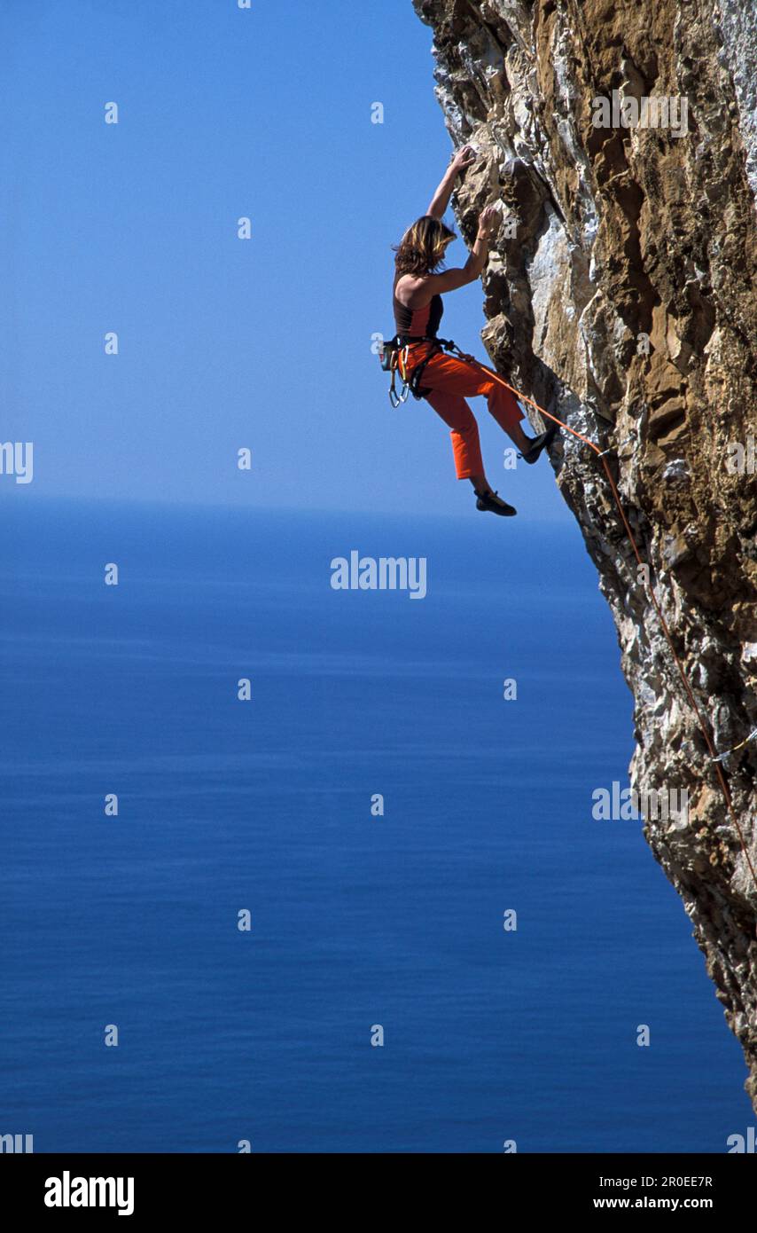 Female free climber scaling rock face, Muzzerone, Portovenere, Cinque ...