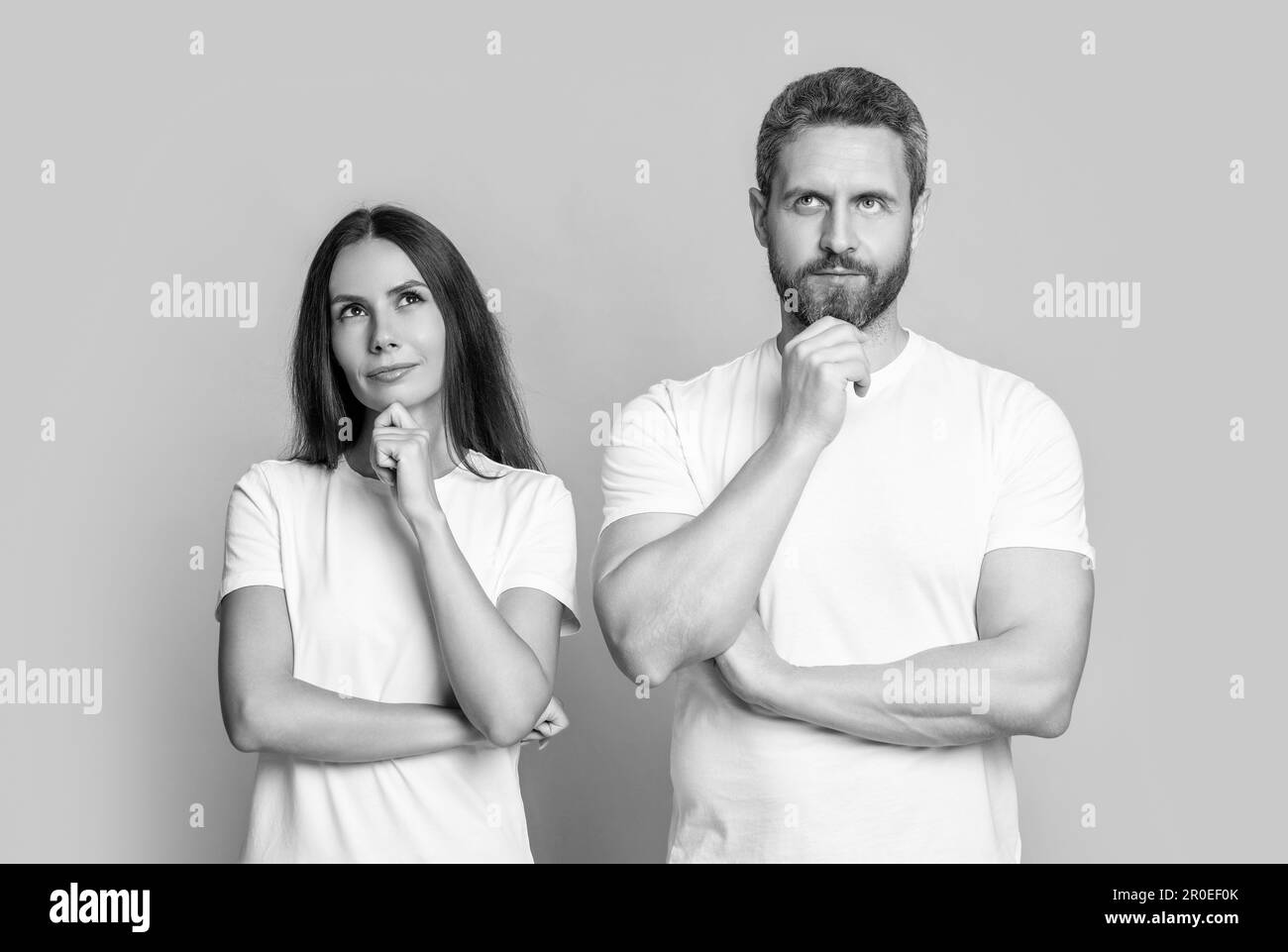 Thinking couple stroking chins studio. Couple thinking isolated on ...