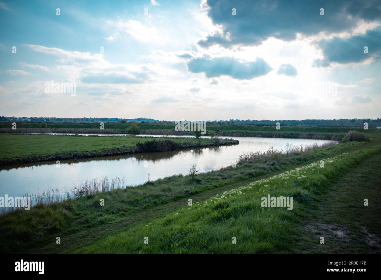 A scenic landscape featuring an unpopulated river with lush green grass ...