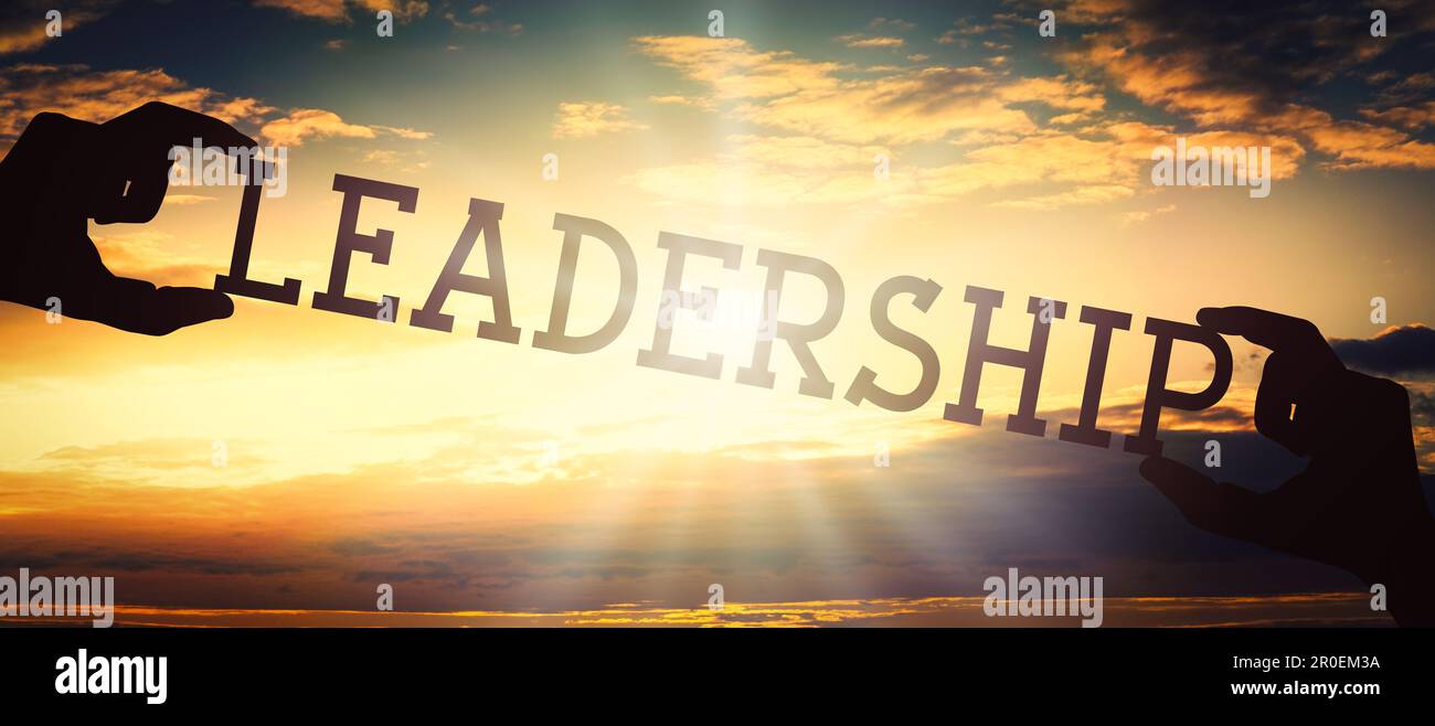 Leadership - human hands holding black silhouette word Stock Photo - Alamy