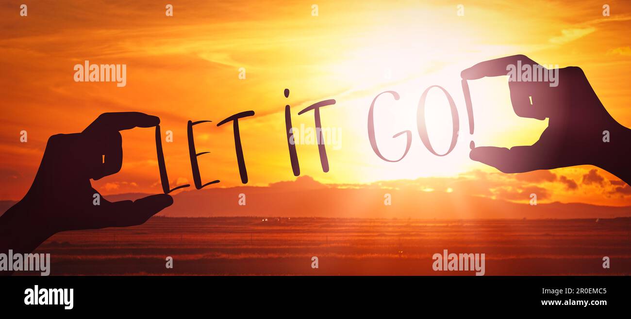 Let it go - human hands holding black silhouette words Stock Photo - Alamy