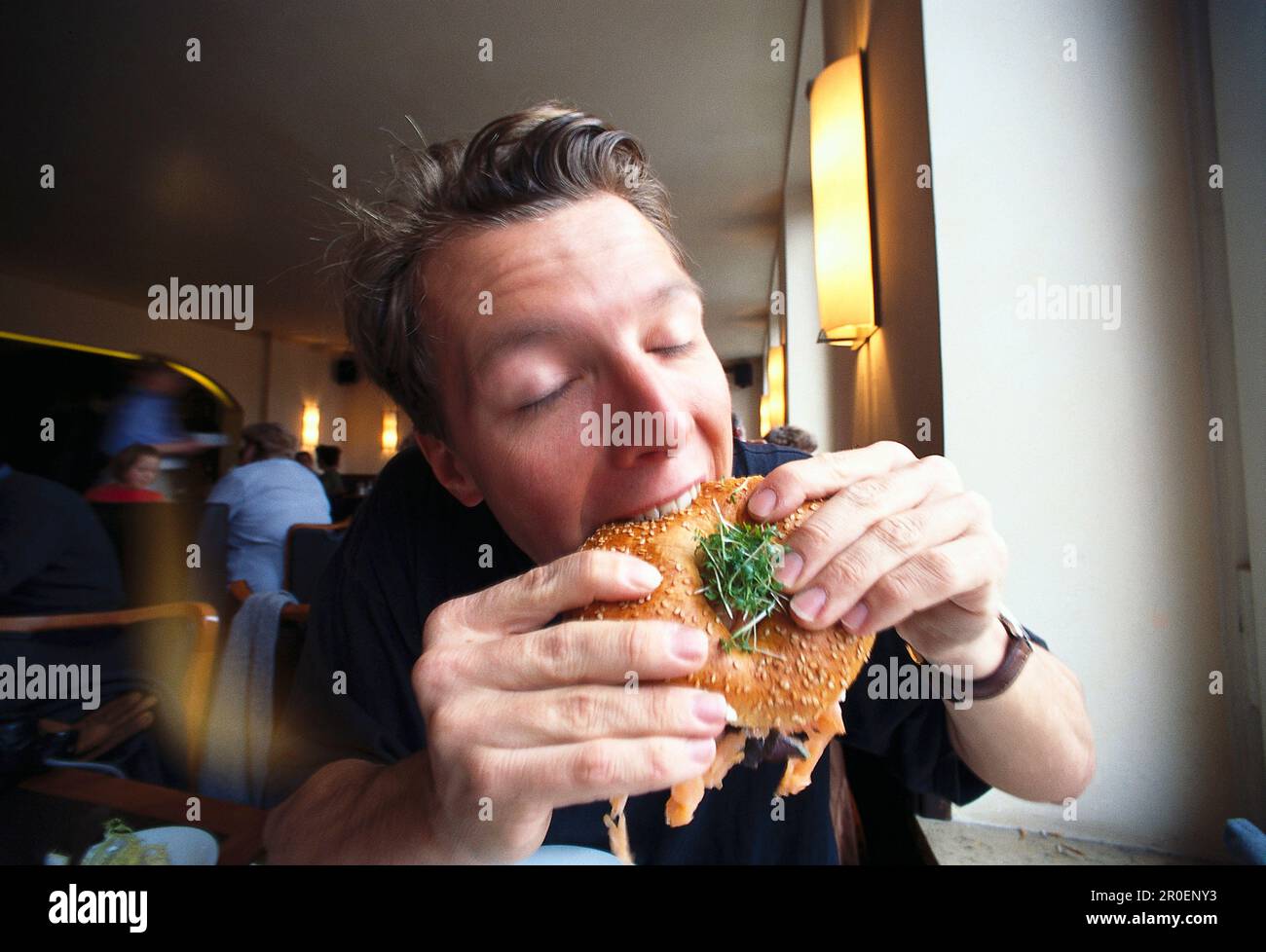 Mann isst Bagel, People Stock Photo - Alamy