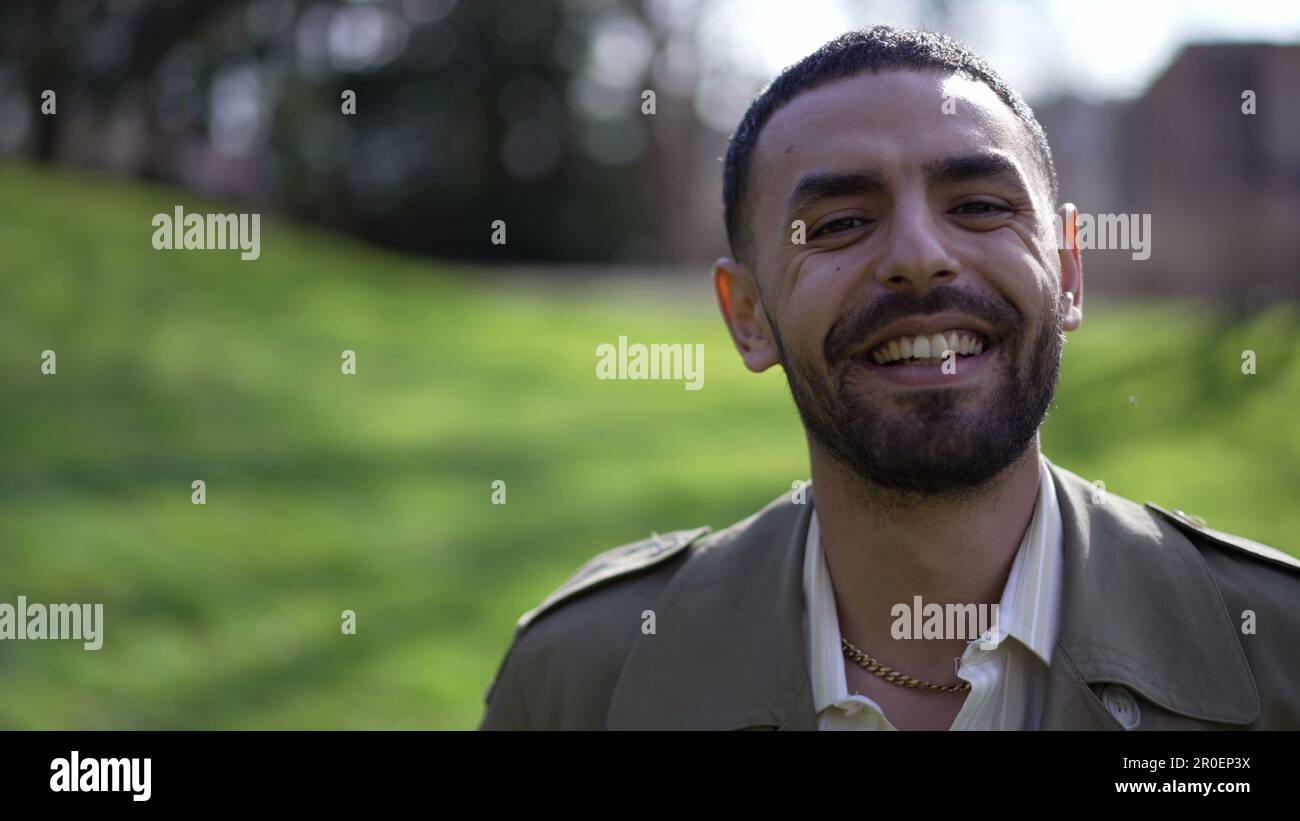 Portrait of a happy Middle Eastern young man walking forward toward ...