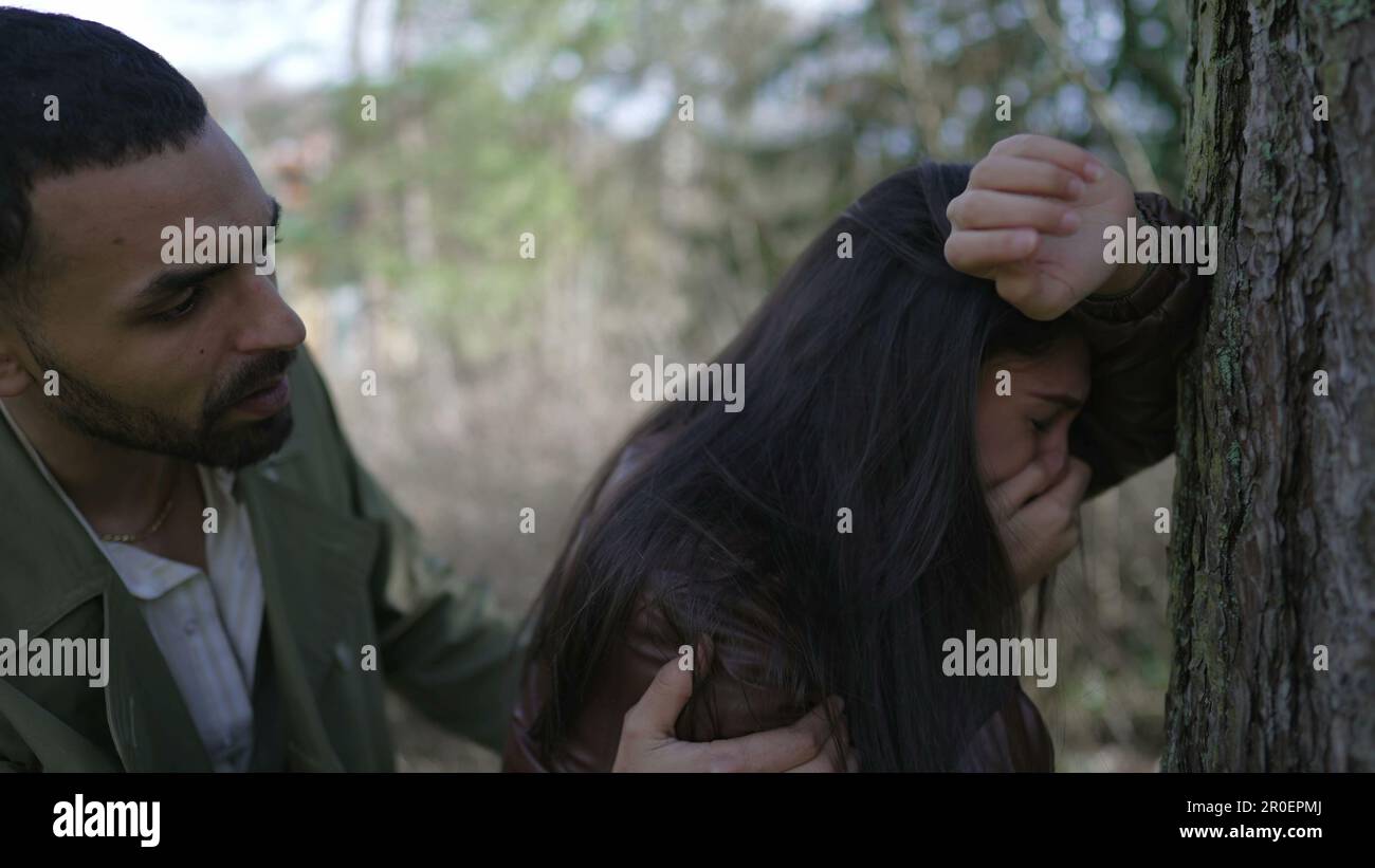 Suffering woman being consoled by boyfriend embrace outside at park ...