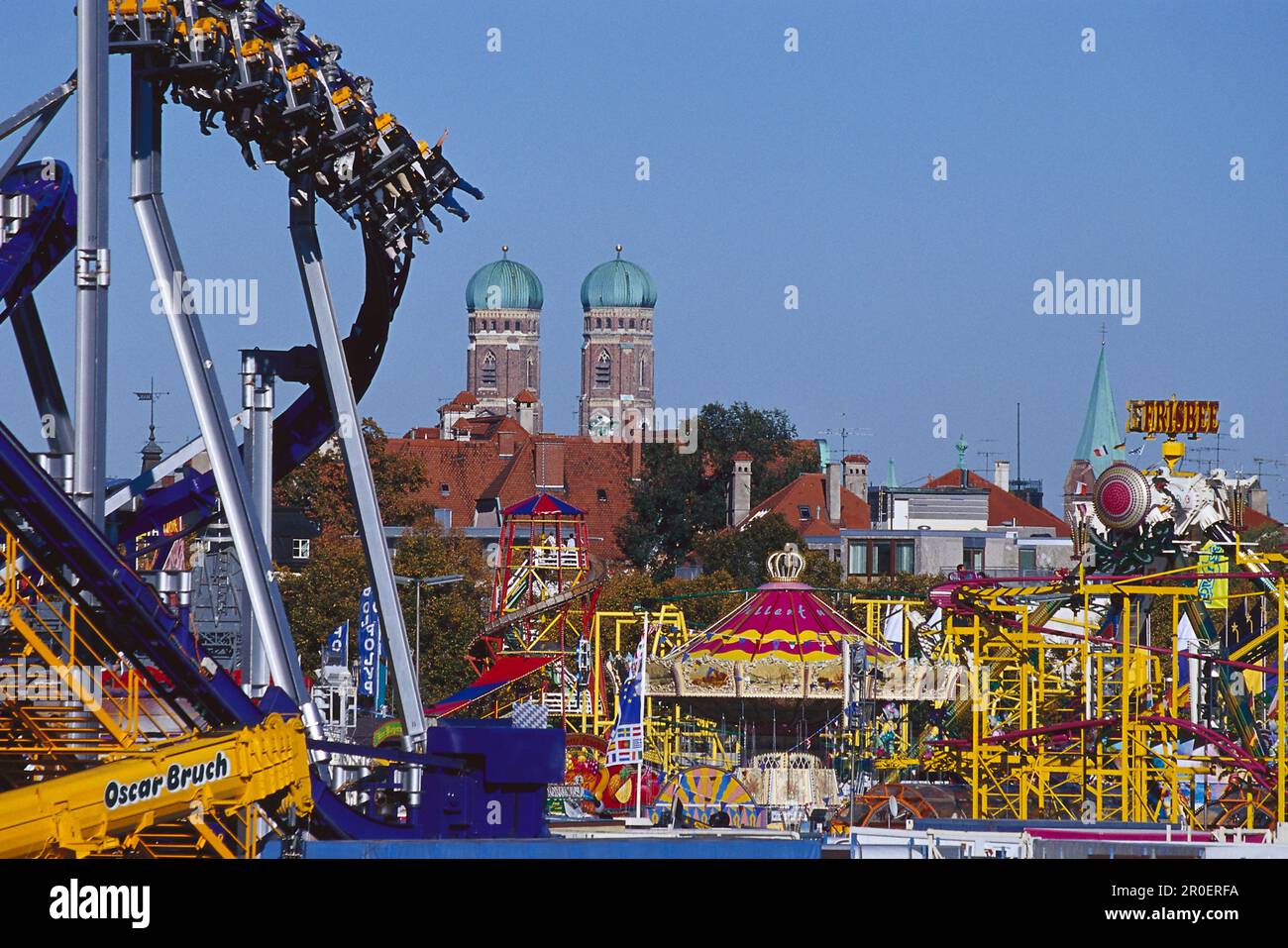 Fairground rides of the Oktoberfest in front of the Church of our Lady ...