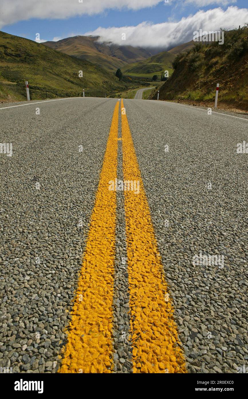 Yellow double medial strip on a country road in Otago, South Island ...