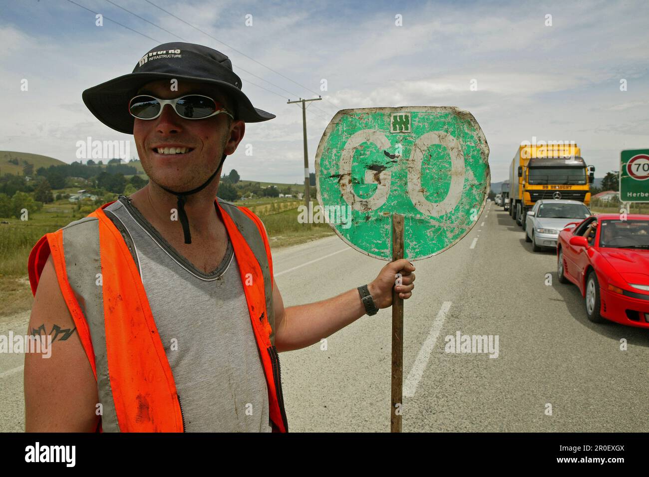Roadworker holding stop and go sign, New Zealand, Oceania Stock Photo ...