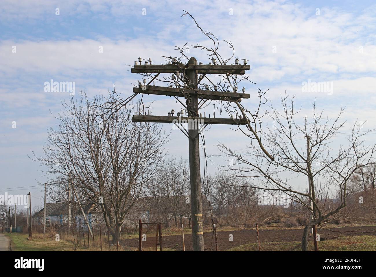 Power line pole with broken wires. Tree branches hang on a pole ...