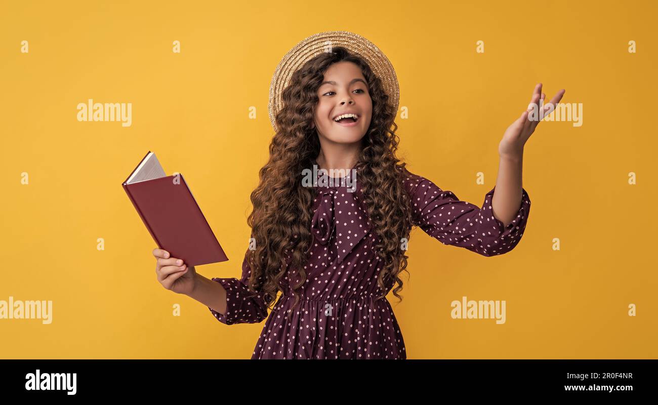positive child with frizz hair recite book on yellow background Stock ...