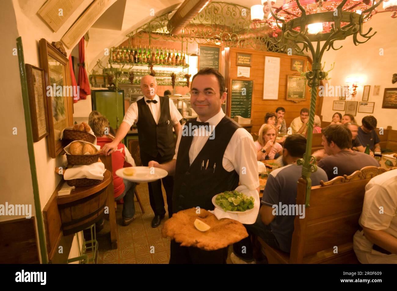 Waiter serving giant Wiener Schnitzel at Restaurant Figlmueller, Vienna ...